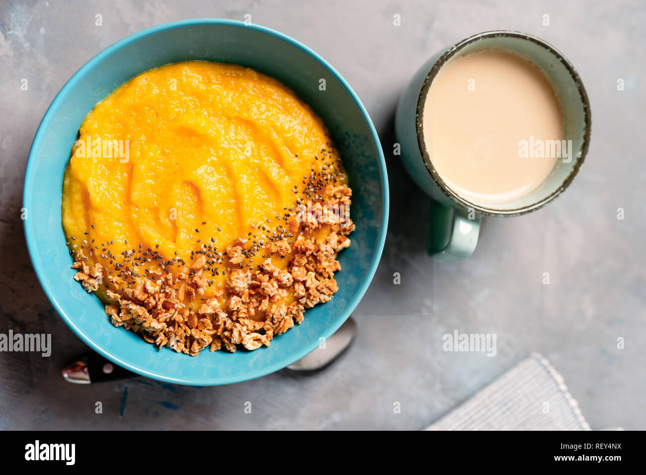 Top view of yellow smoothie bowl with granola in blue plate Stock Photo ...