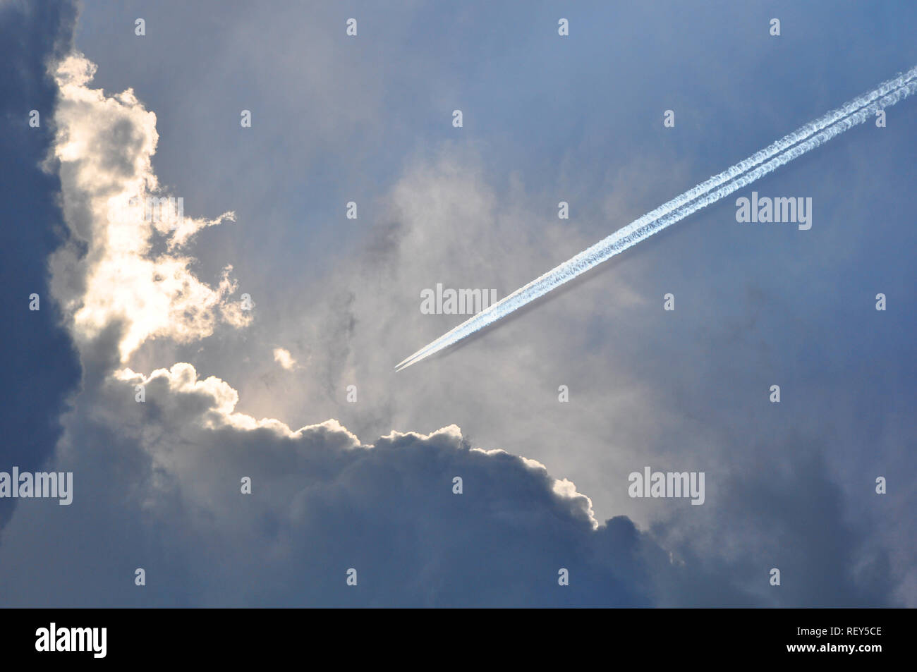 Aircraft contrail seen from the ground, against the cloudy skies Stock ...