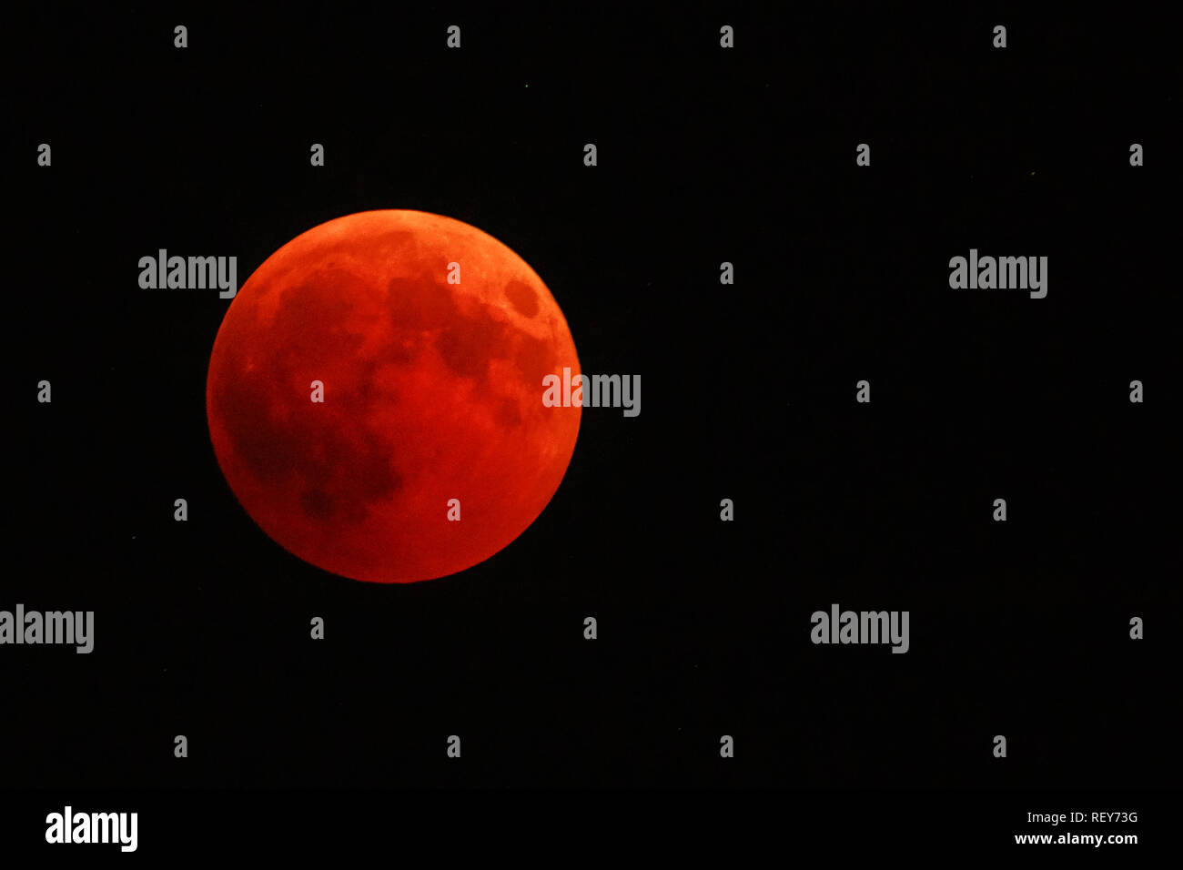 Full red moon over dark black sky background at night. The total phase ...
