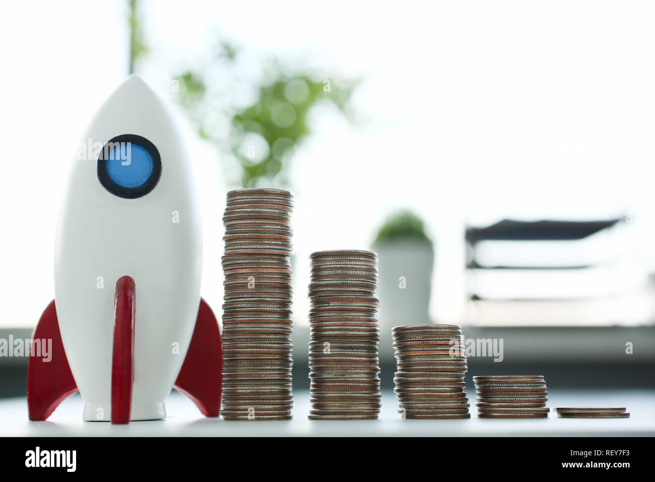 Rocketship stand with coin row ready go to moon Stock Photo - Alamy