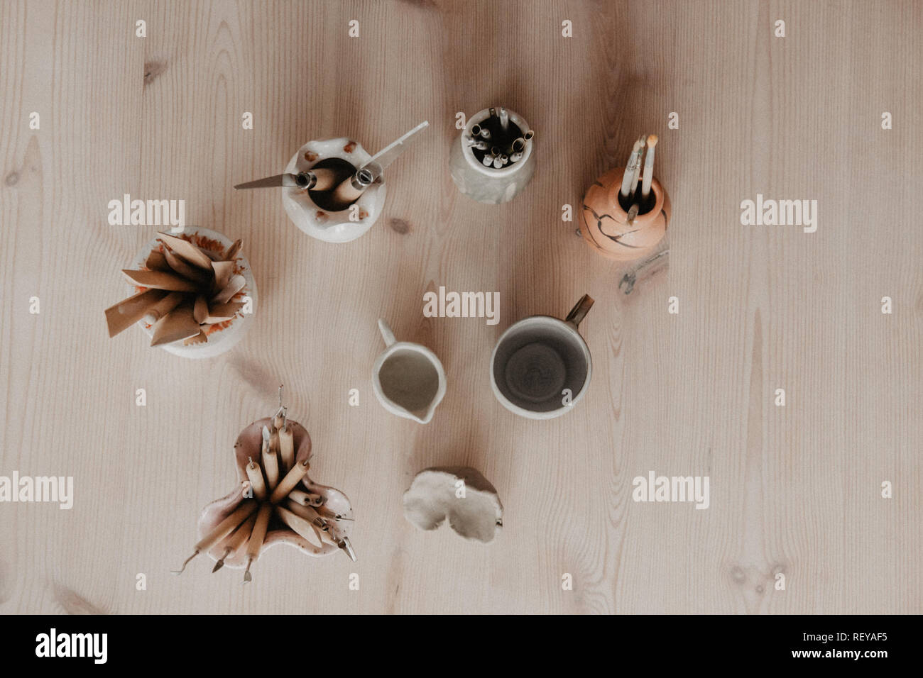 Set of dirty art and craft sculpting tools on wooden table in pottery ...