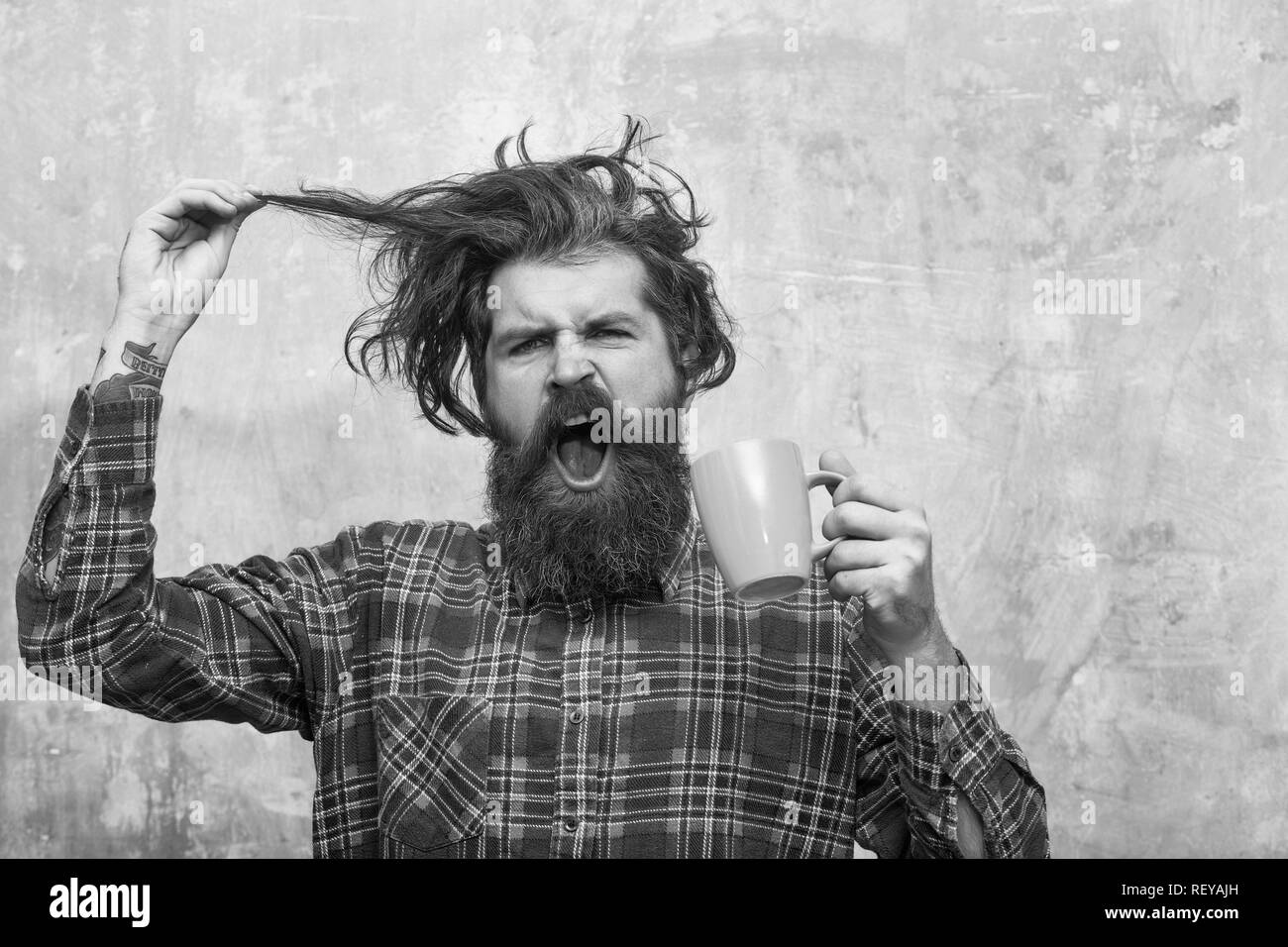 Angry bearded man holding fringe hair and blue cup Stock Photo - Alamy