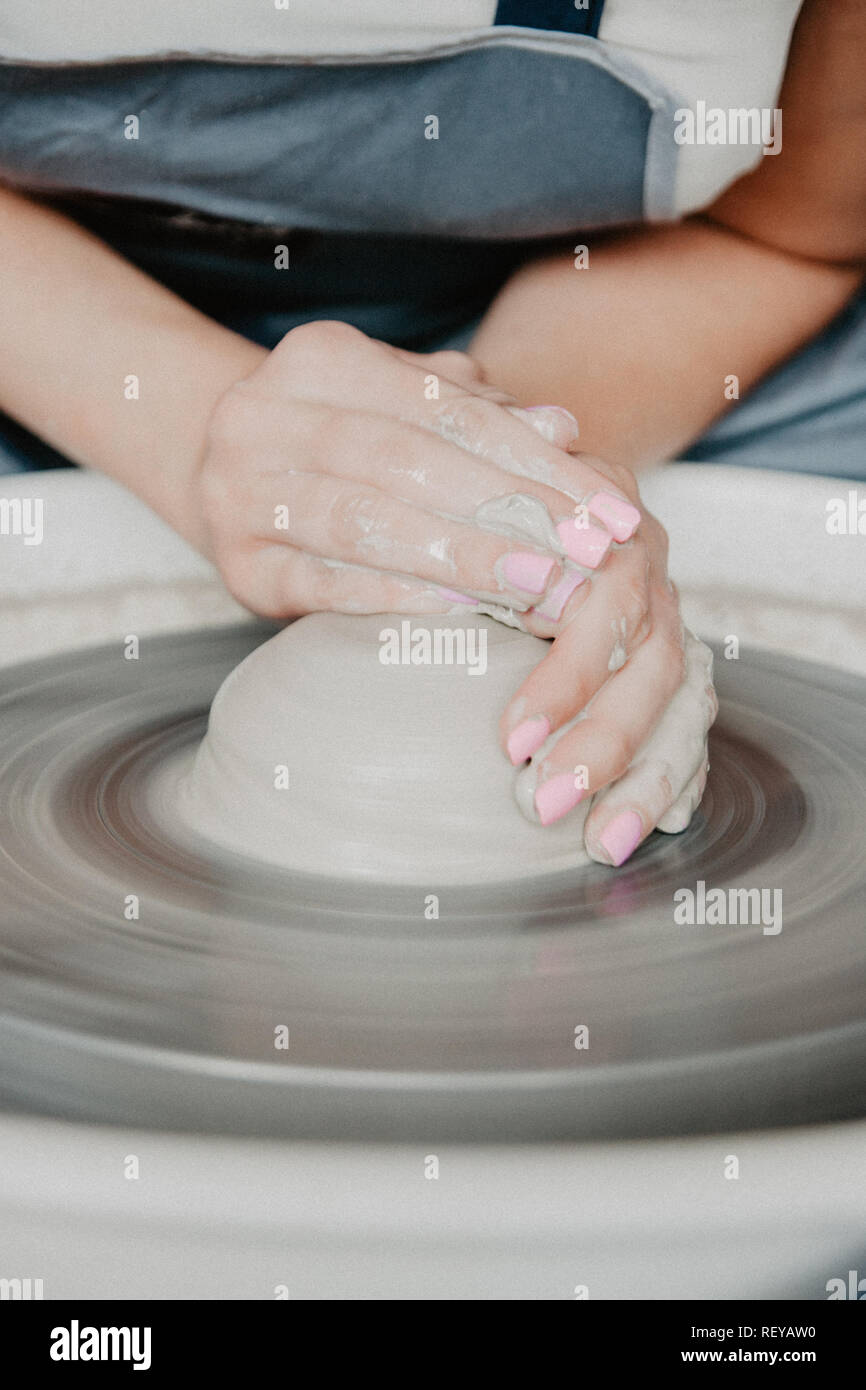 Creating a jar or vase of white clay close-up. Woman hands making clay ...