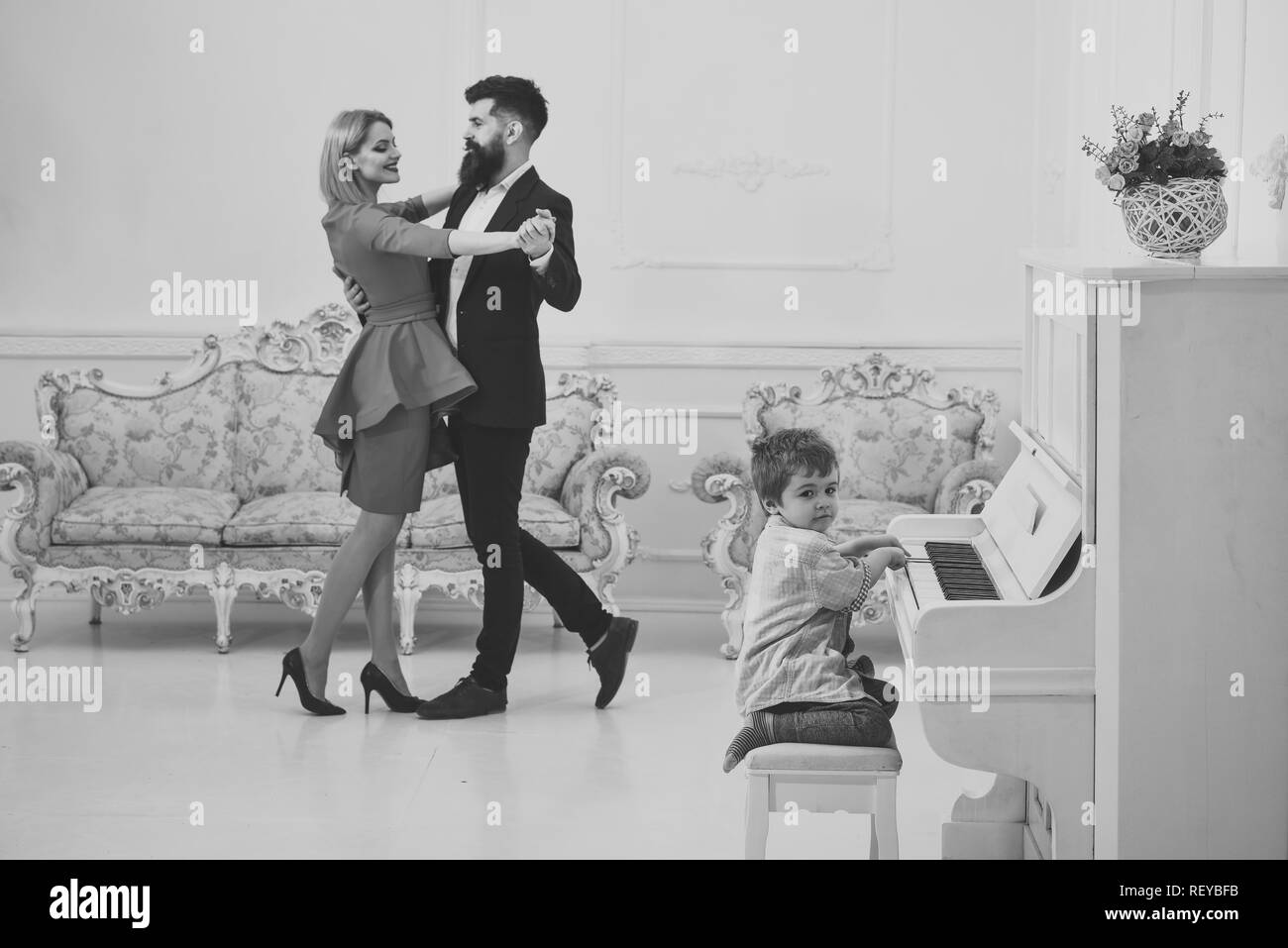 Rich parents enjoy parenthood. Boy adorable try to play piano musical ...