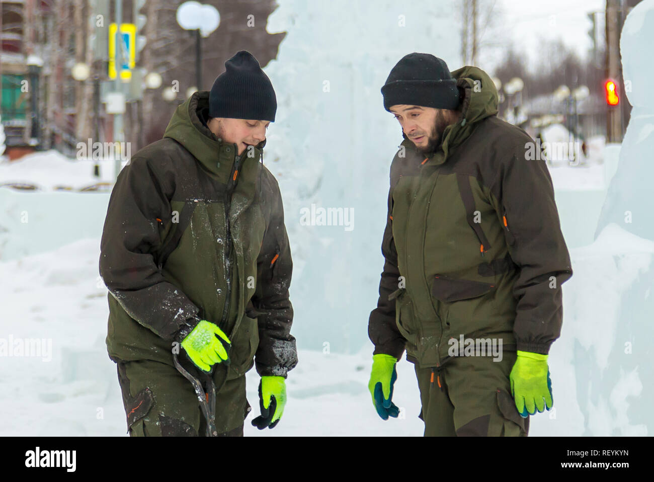 Workers on the construction site of the ice town discuss a plan for ...