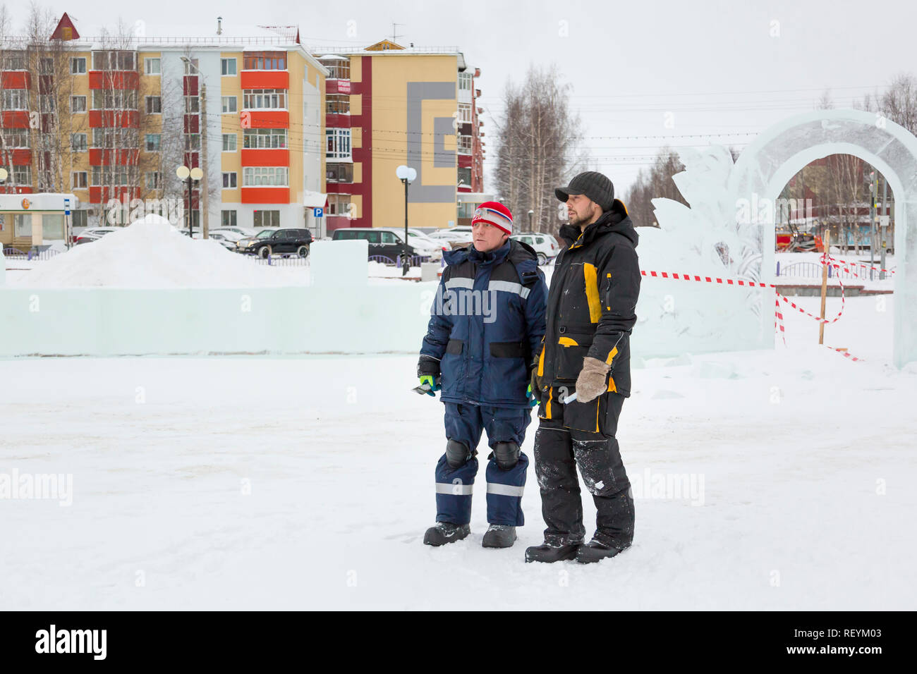 Workers on the construction site of the ice town discuss a plan for ...