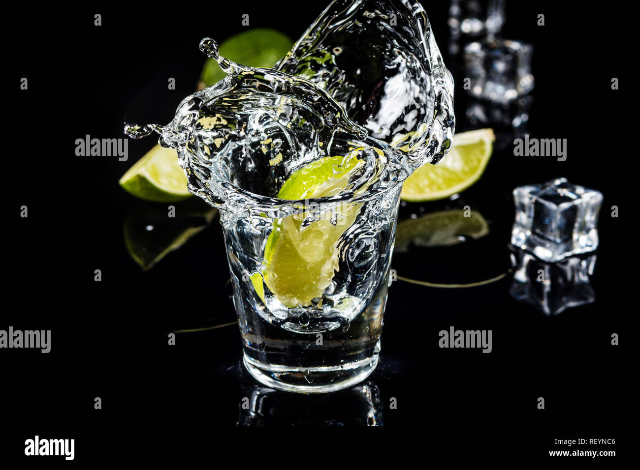 Mexican traditional Tequila splash lime on black background with ice ...