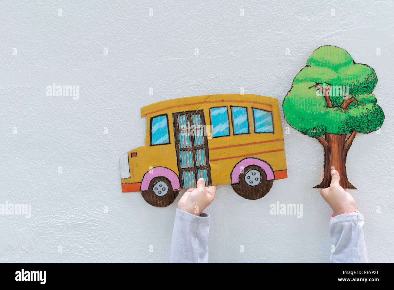 back to school concept. The children are holding a yellow school bus ...