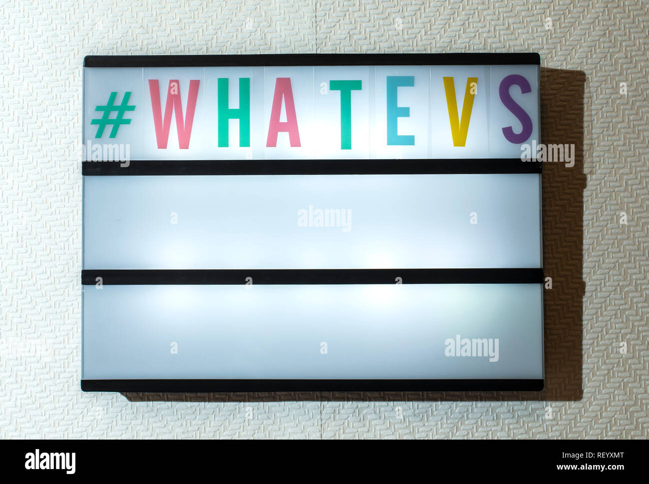 Message #whatevs on illuminated board. Incuriosity concept with text ...