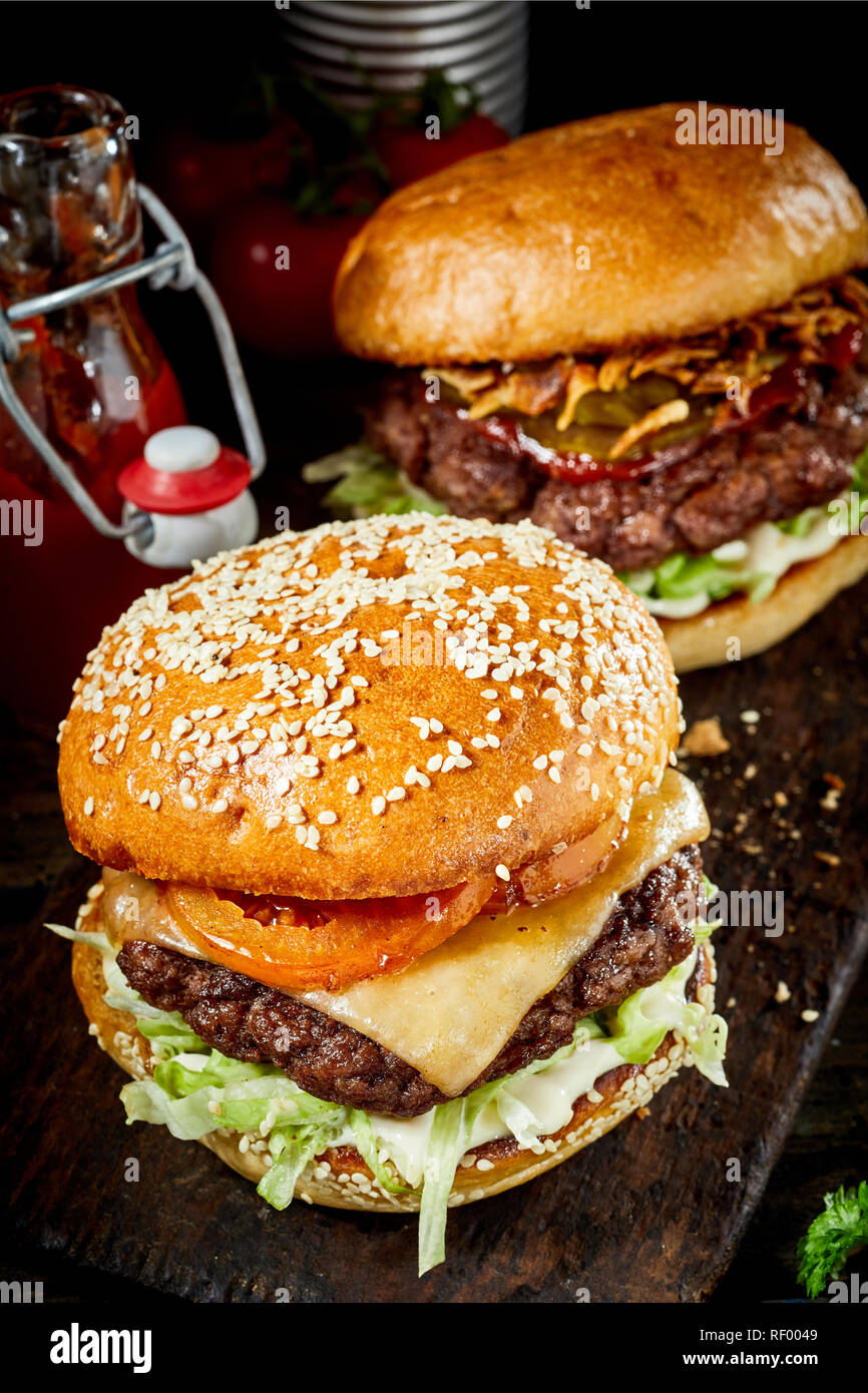 Traditional beef burger or cheeseburger on a sesame bun viewed close up ...