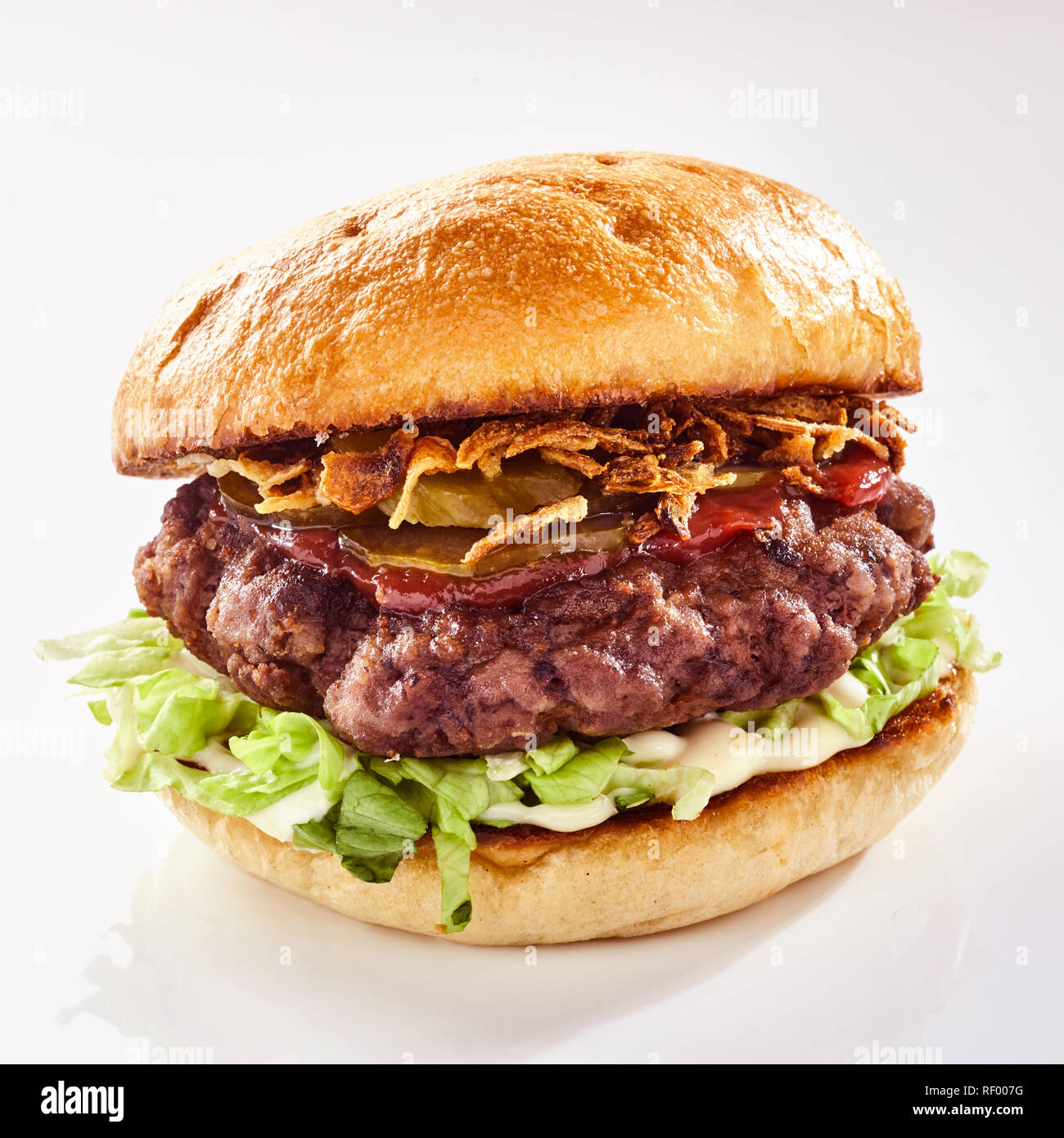 Pork belly burger with crisp crackling on a bed of lettuce on a toasted ...