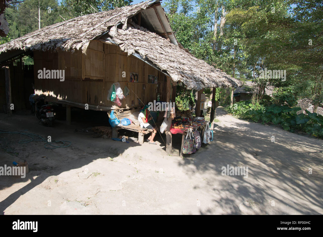 person at a Huts in Hmong Thailand village villagers sit sat sitting ...