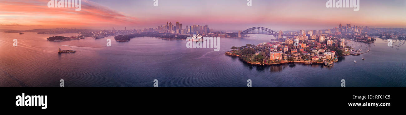 Red dawn sun light reflecting in waters of Sydney harbour and bays ...