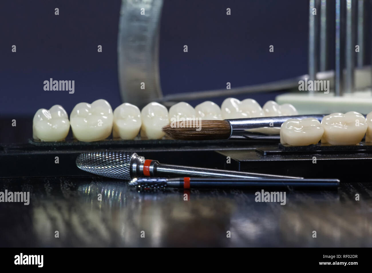 Acrylic teeth and dental instruments. Stomatologic instrument, close up ...