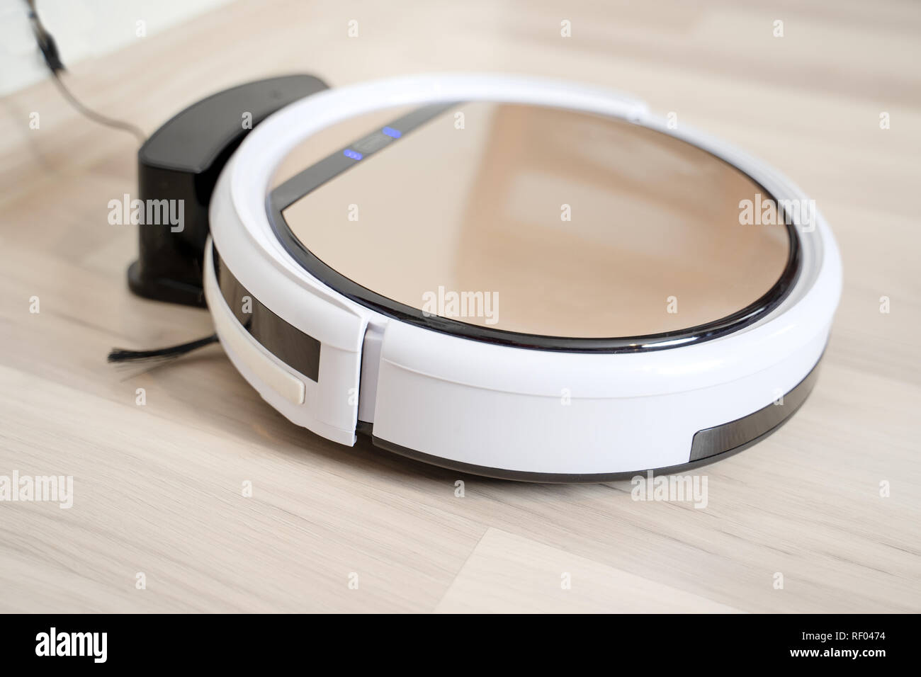 Robot vacuum cleaner on charging dock after it is finished. Modern ...