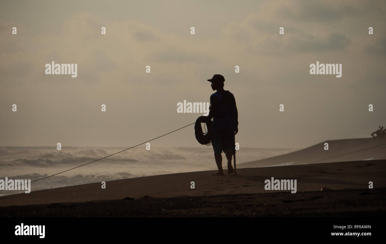 fisherman pulling nets from sea at sunset on sandy beach. Fisherman ...