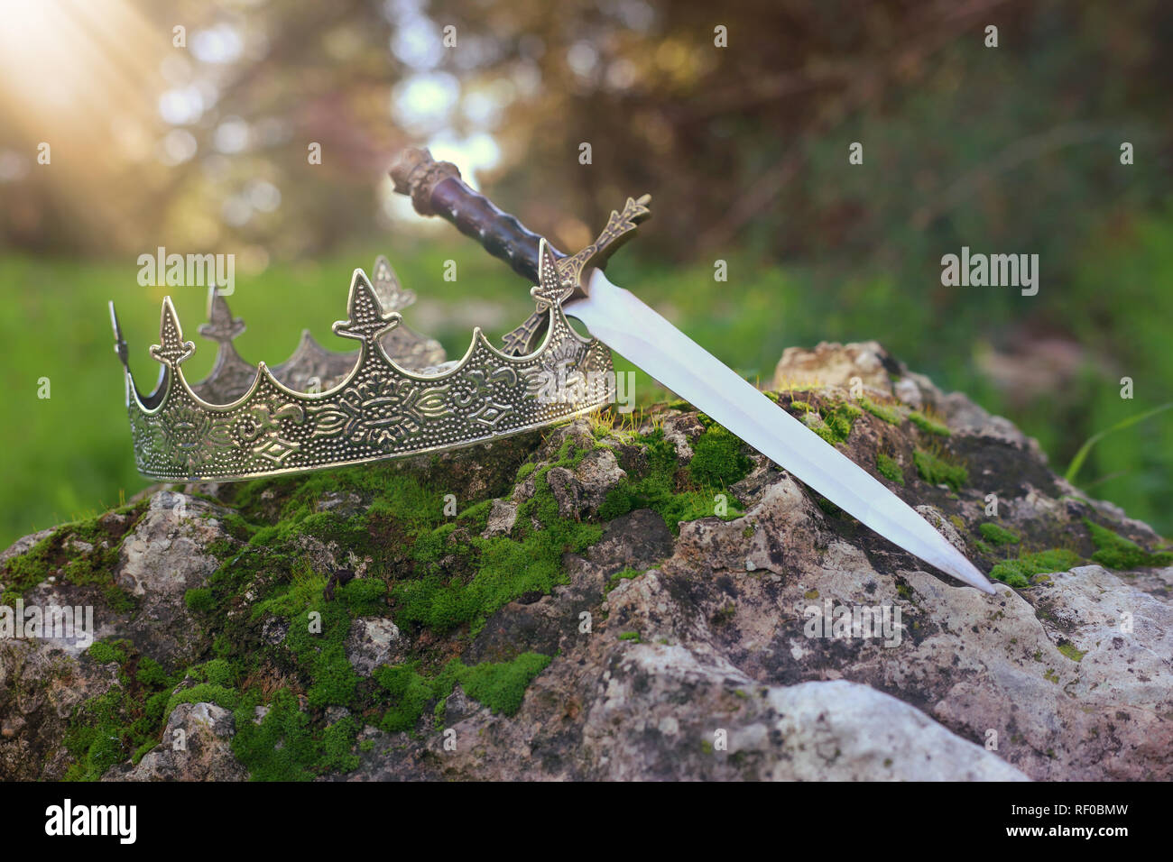 mysterious and magical photo of silver king crown and sword over the ...