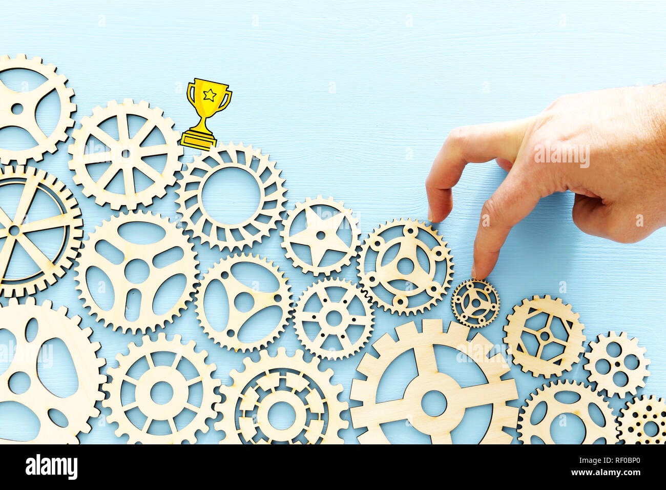 hand placing a cogwheel in set of gears mechanism Stock Photo - Alamy