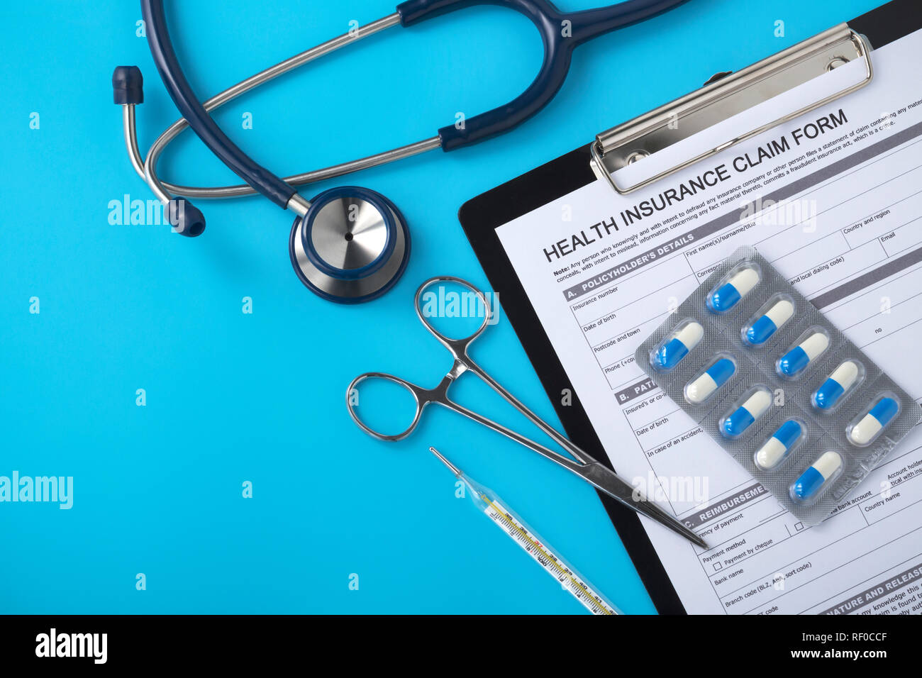 Health insurance form with stethoscope, pills and doctor tools on blue ...