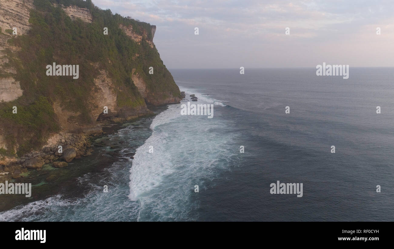 aerial view rocky ocean coastline at sunset. seascape waves break on ...