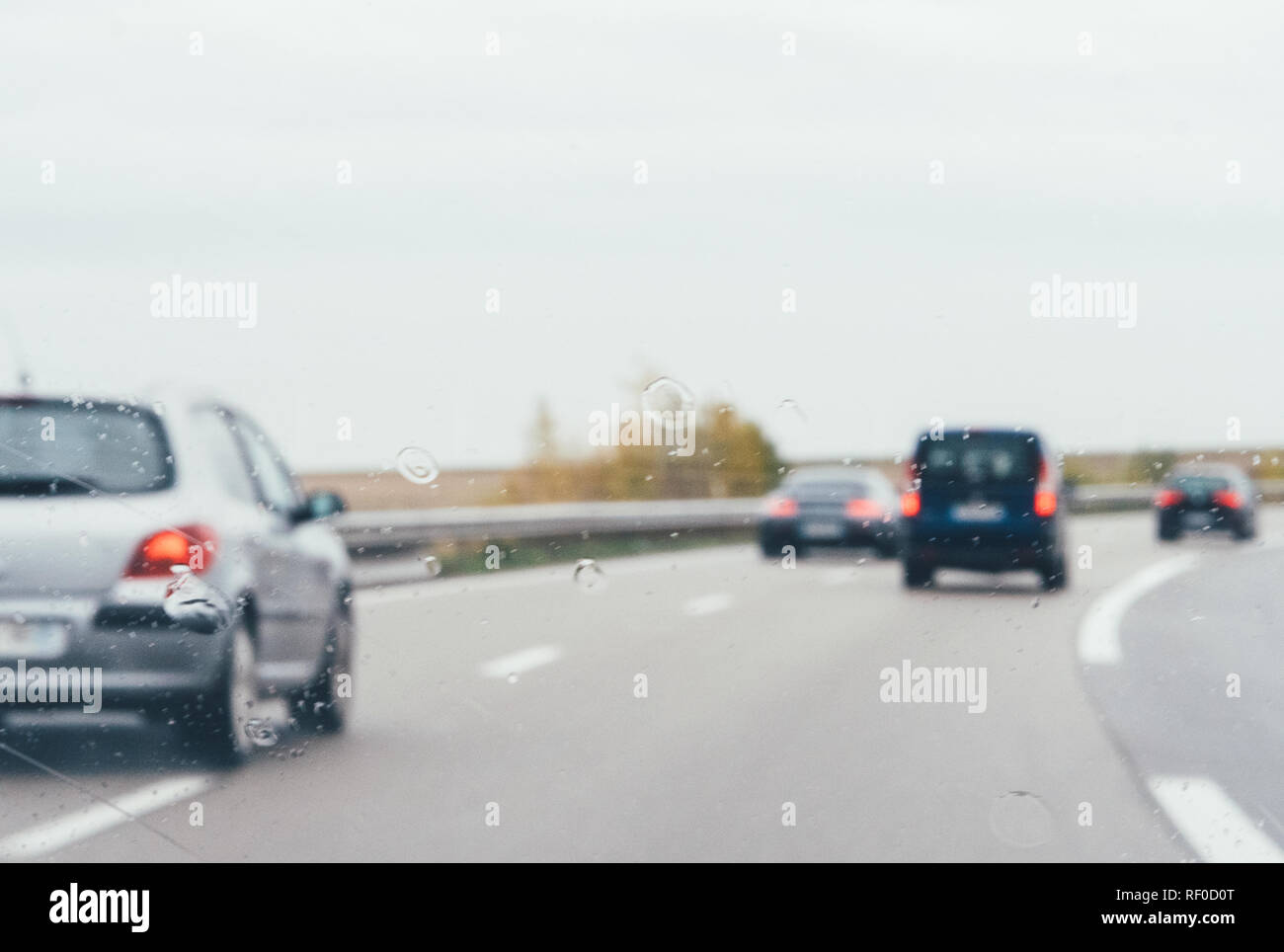 Defocused view of cars on german highway autobahn on a rainy day focus ...