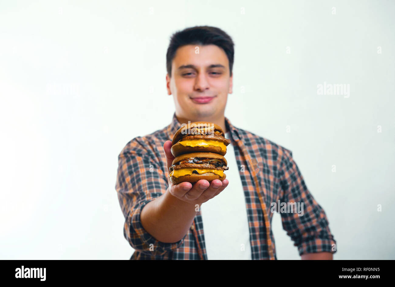 happy man holds two burger in hand on white background Stock Photo - Alamy