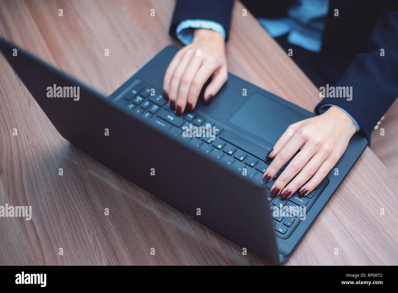 The girl works at a laptop in the office. Hands with laptop close up ...