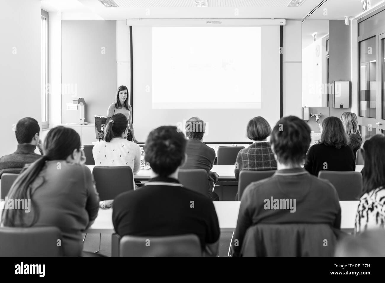 Woman giving presentation in lecture hall at university Stock Photo - Alamy