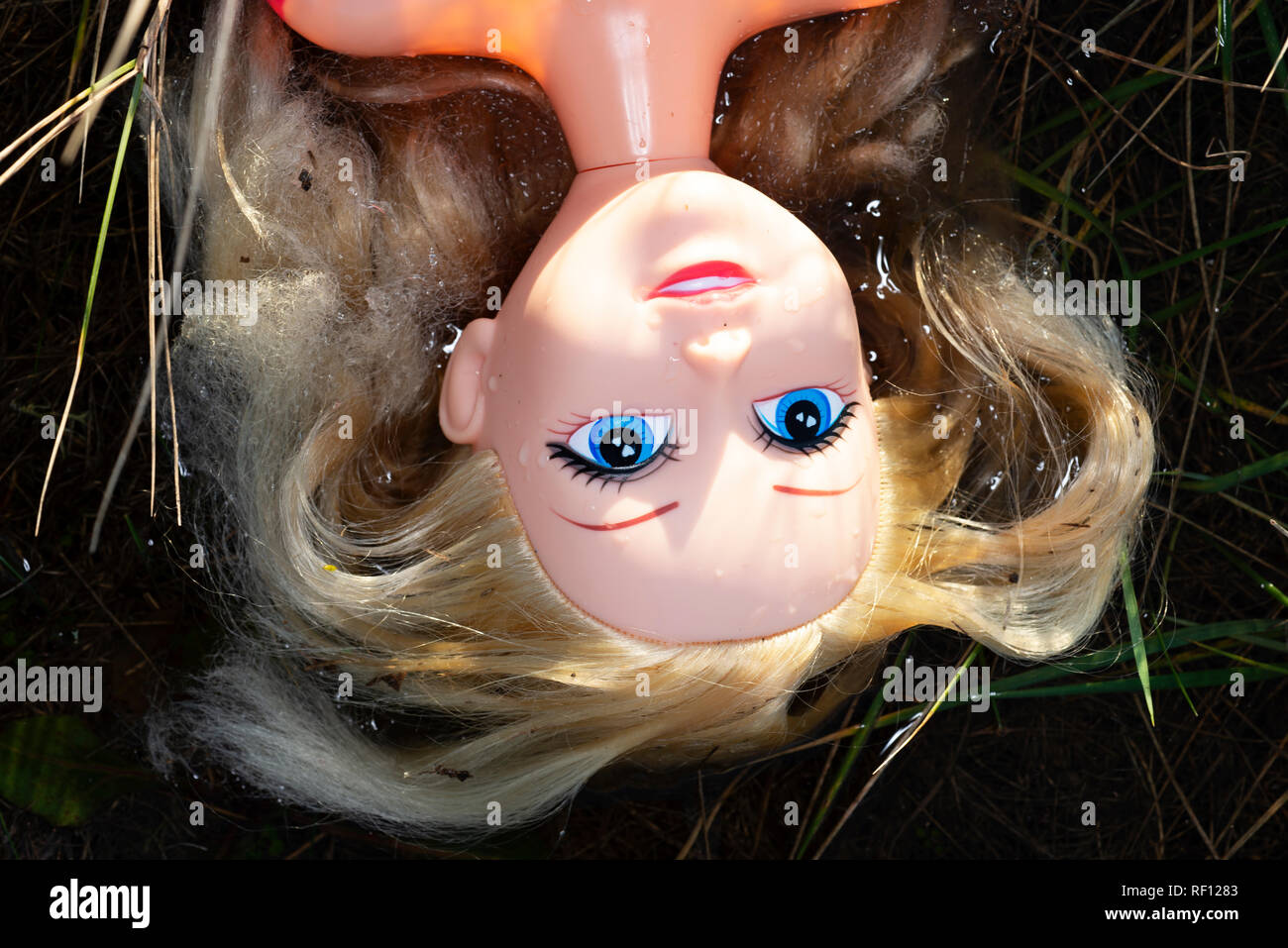 Toy doll upside down in a stream Stock Photo - Alamy