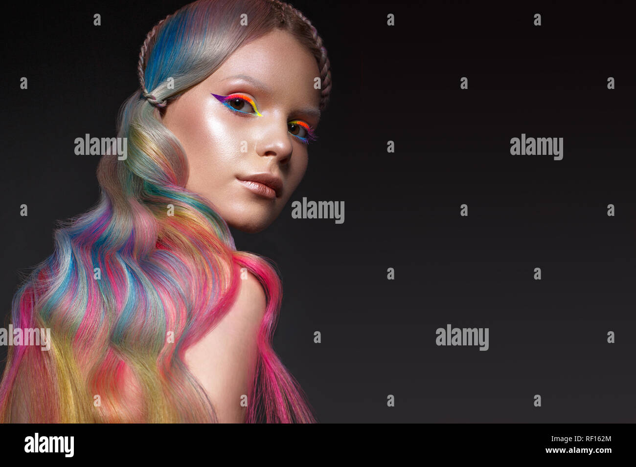 Beautiful girl with multi-colored hair and creative make-up and ...