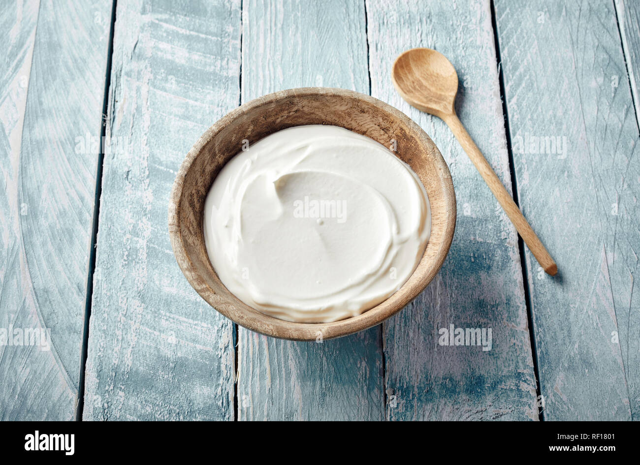 Healthy thick creamy natural Greek yogurt in a rustic wooden bowl with ...