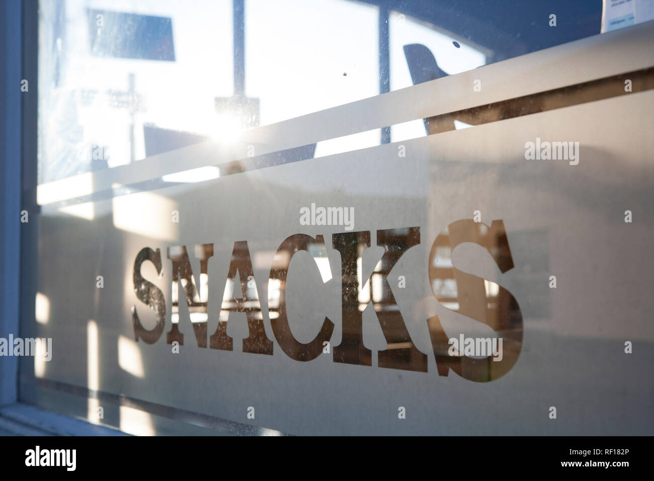A sign advertising snacks in the window of a cafe at sunrise in West ...