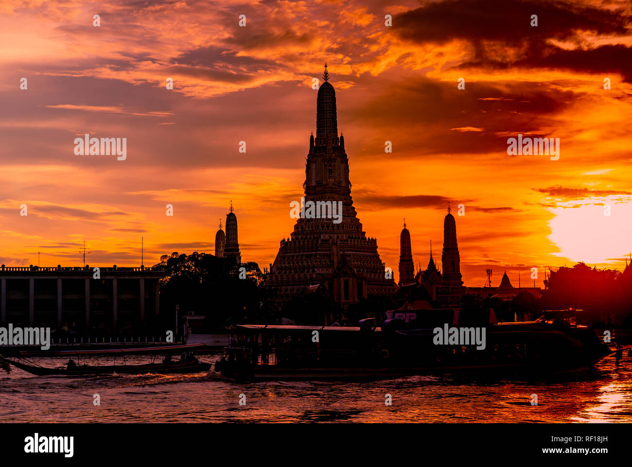 Wat Arun Ratchawararam at sunset with beautiful red and orange sky and ...