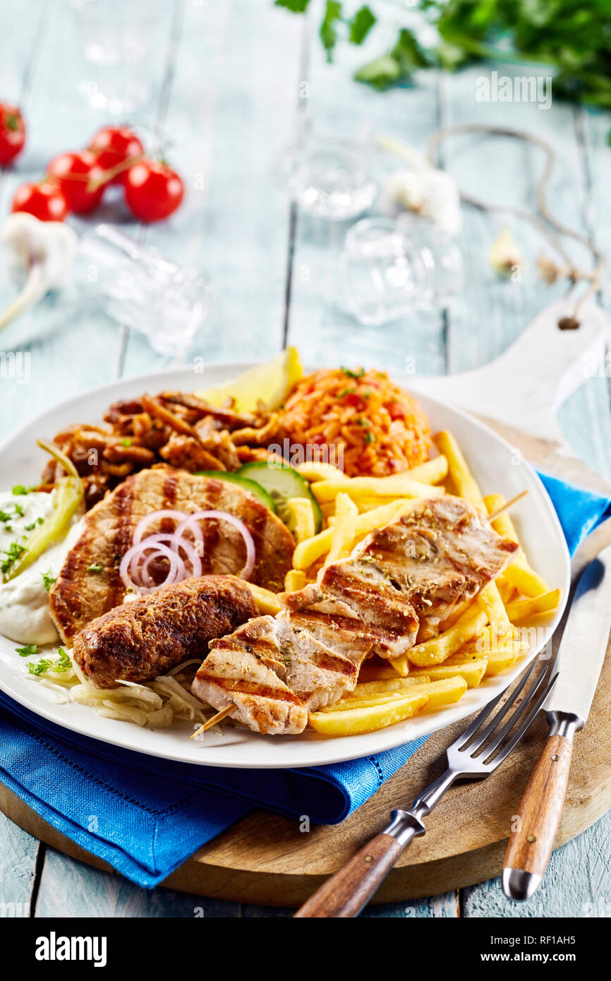 Traditional Greek grill plate with an assortment of spicy grilled meats ...