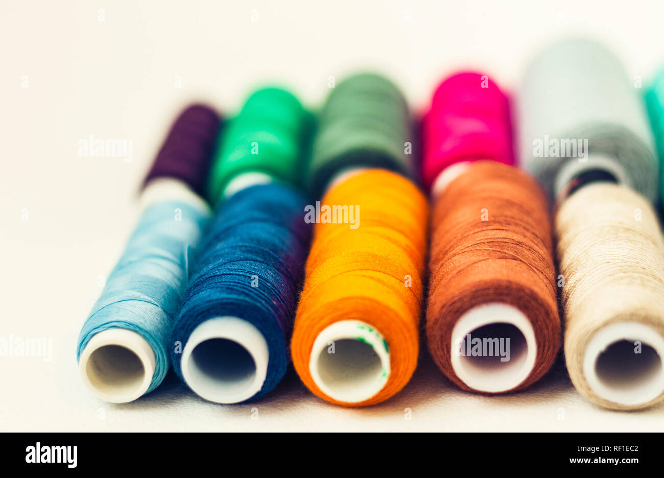 Colored sewing thread coils on white background with copy space for ...