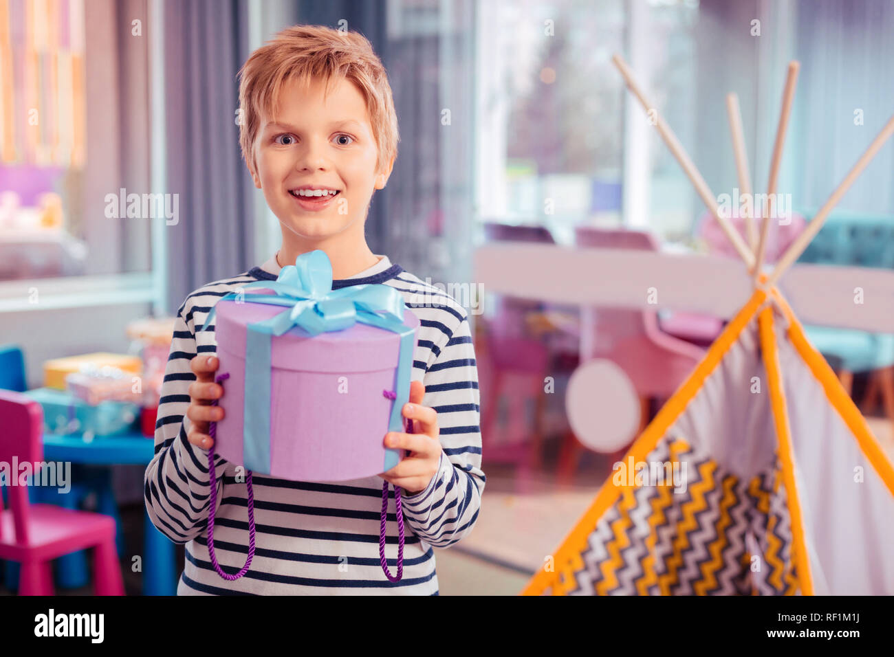 Kind teenager demonstrating box with present from parents Stock Photo ...