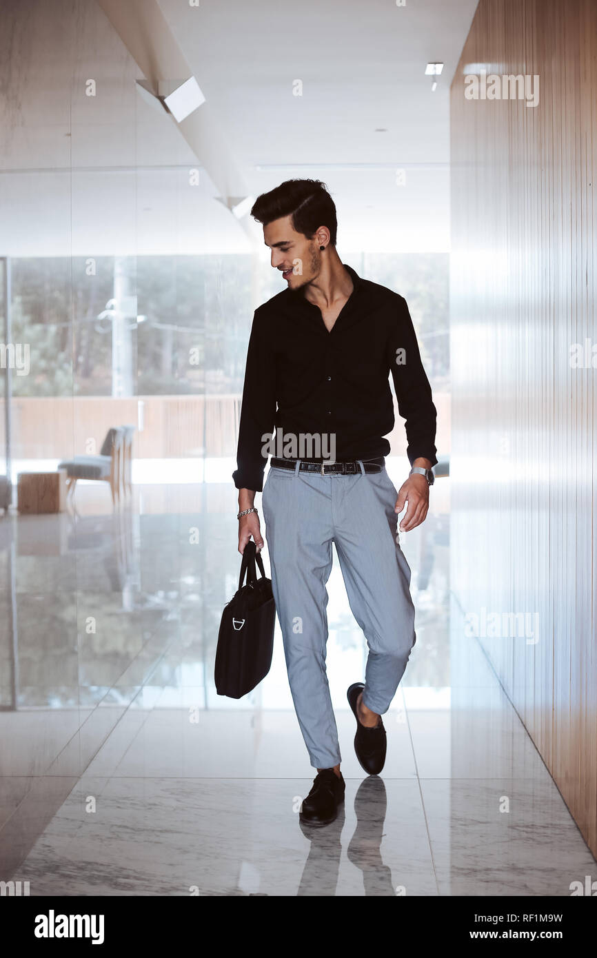 Casual business man walking inside office center Stock Photo - Alamy
