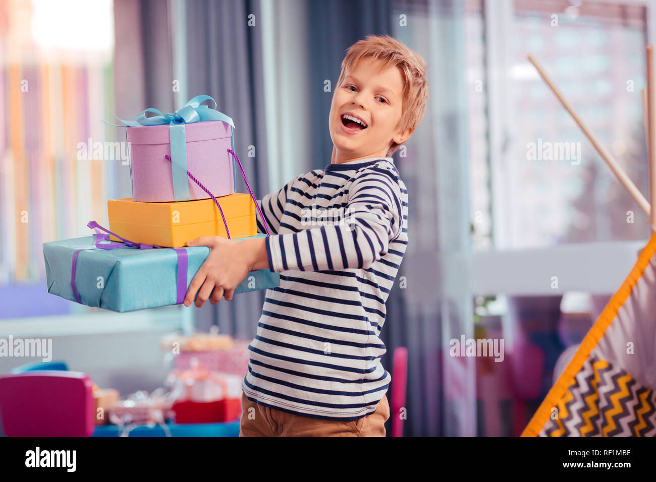 Positive delighted boy posing on camera with presents Stock Photo - Alamy