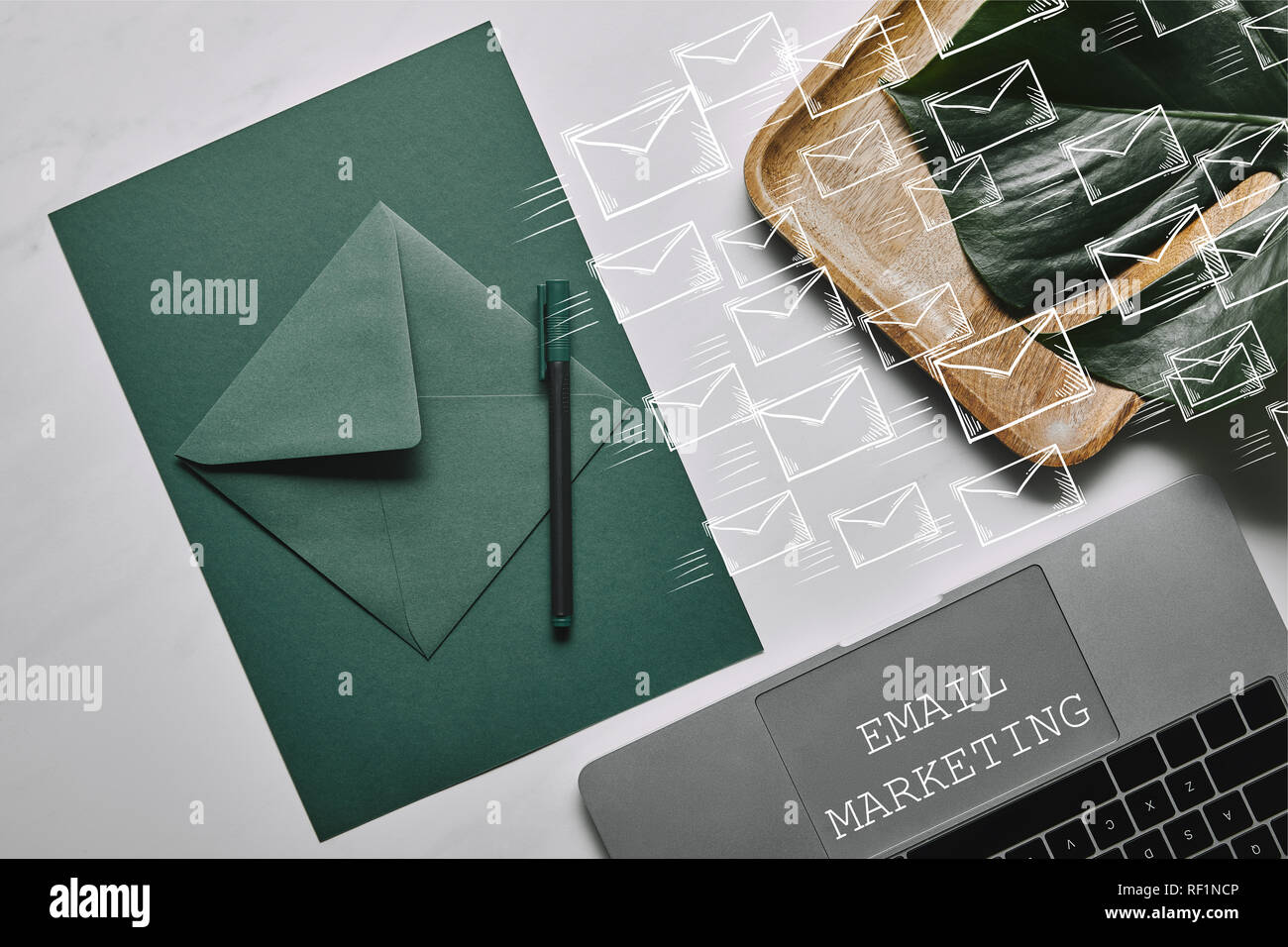 Green paper for letter template by laptop on white marble background ...