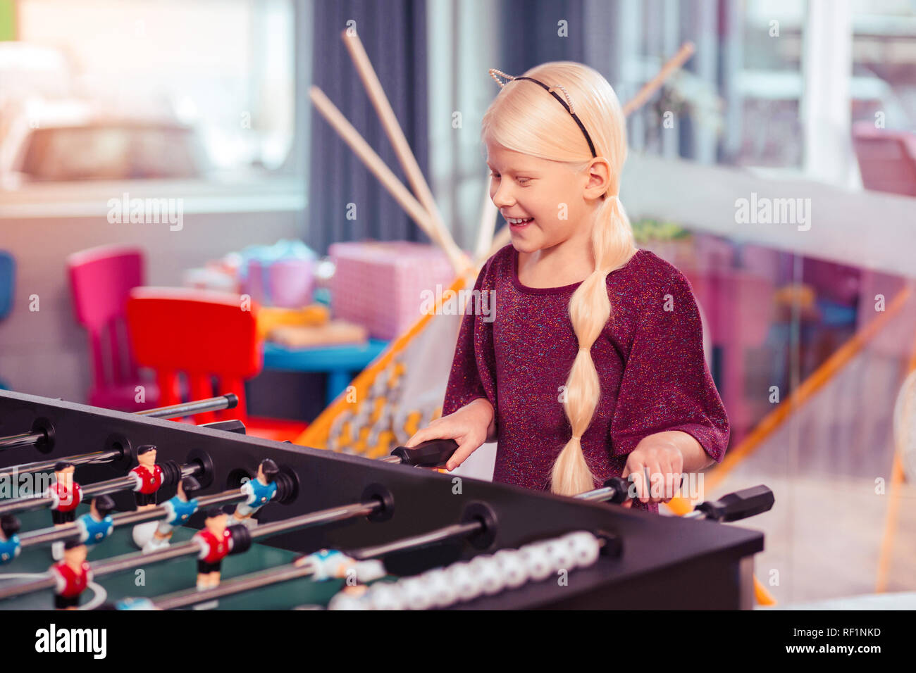 Positive delighted child standing near table game Stock Photo - Alamy