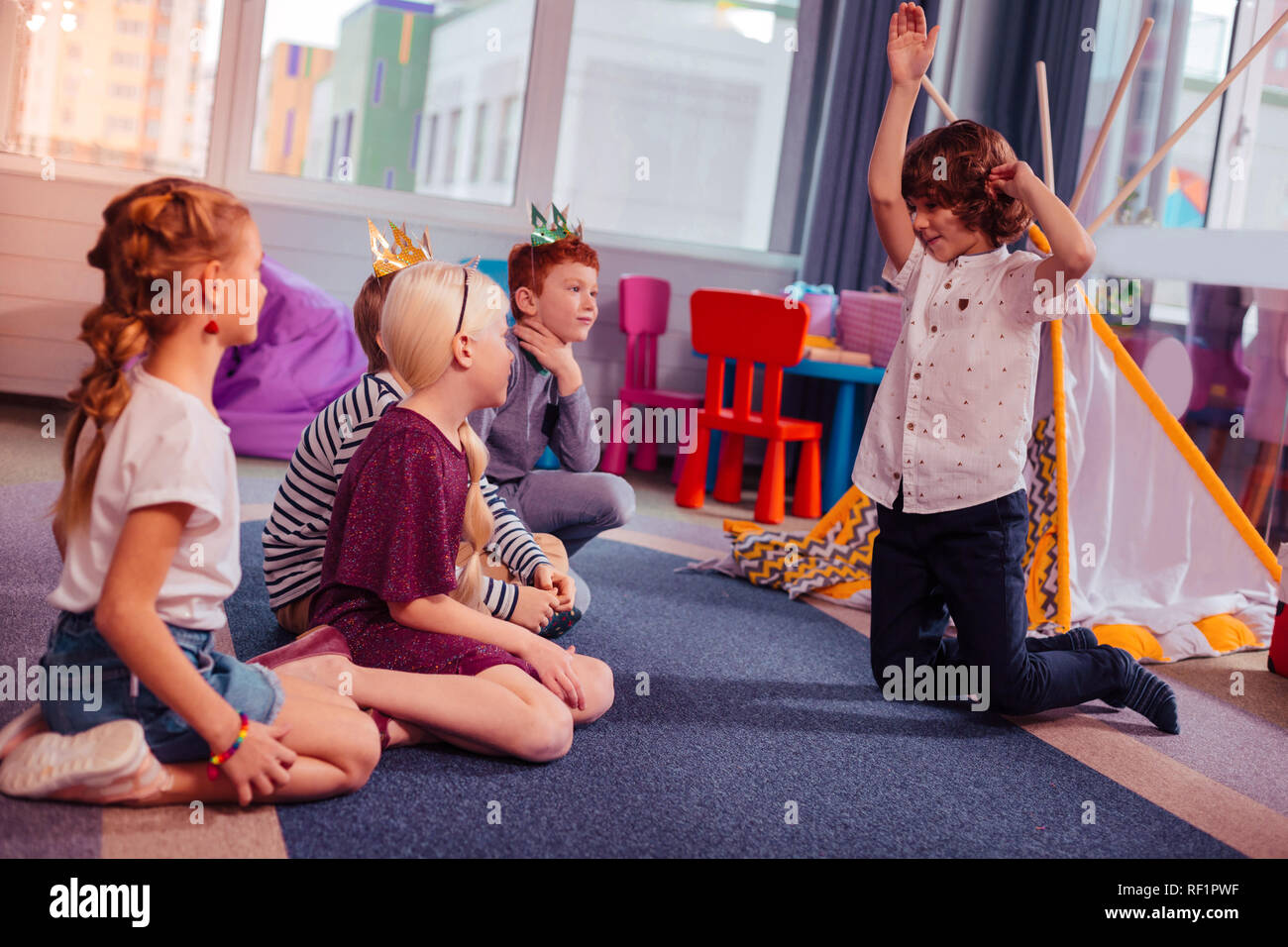 Positive delighted children looking at their friend Stock Photo - Alamy