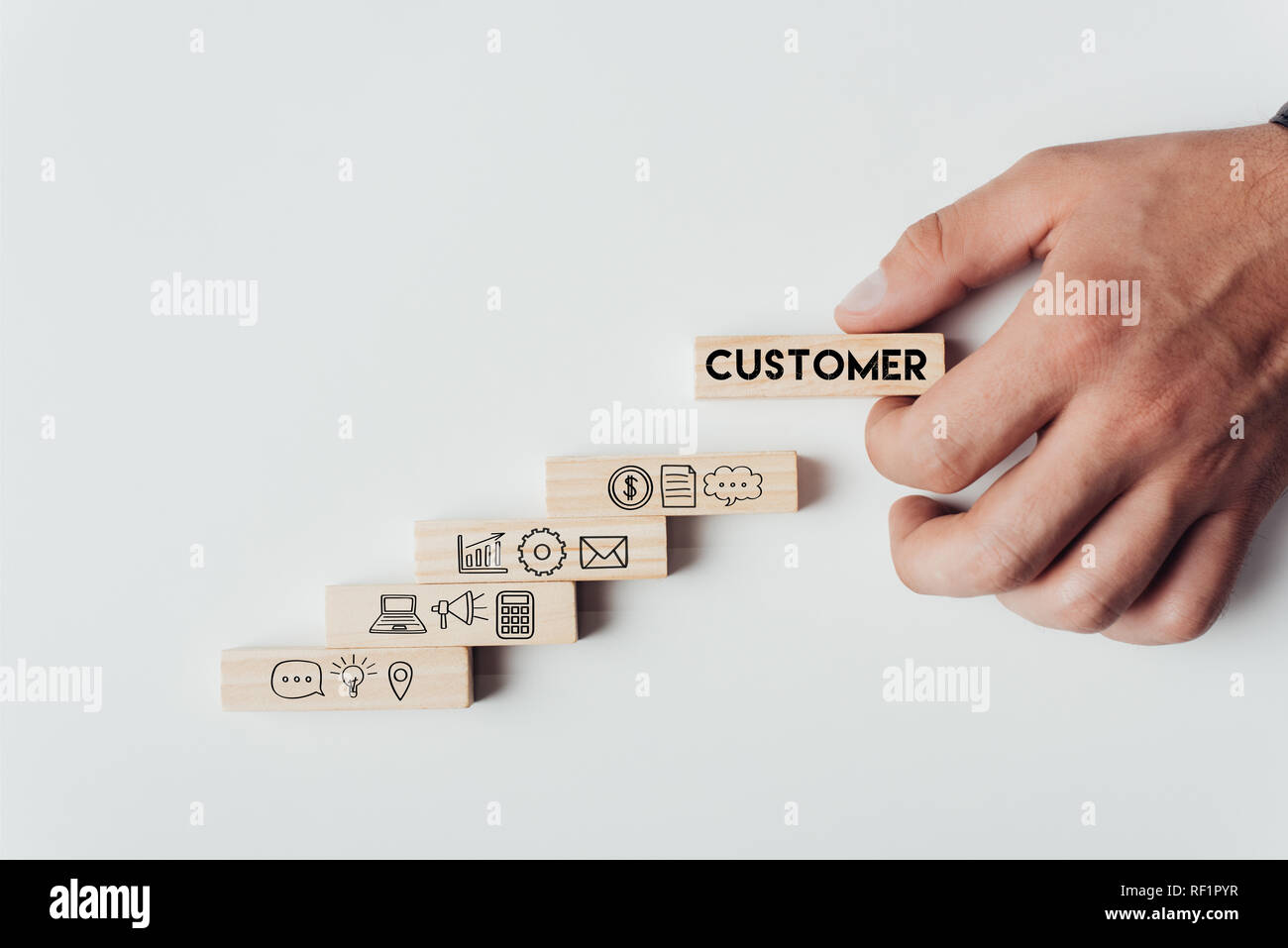 cropped view of man holding wooden block with word 'customer' on top of ...