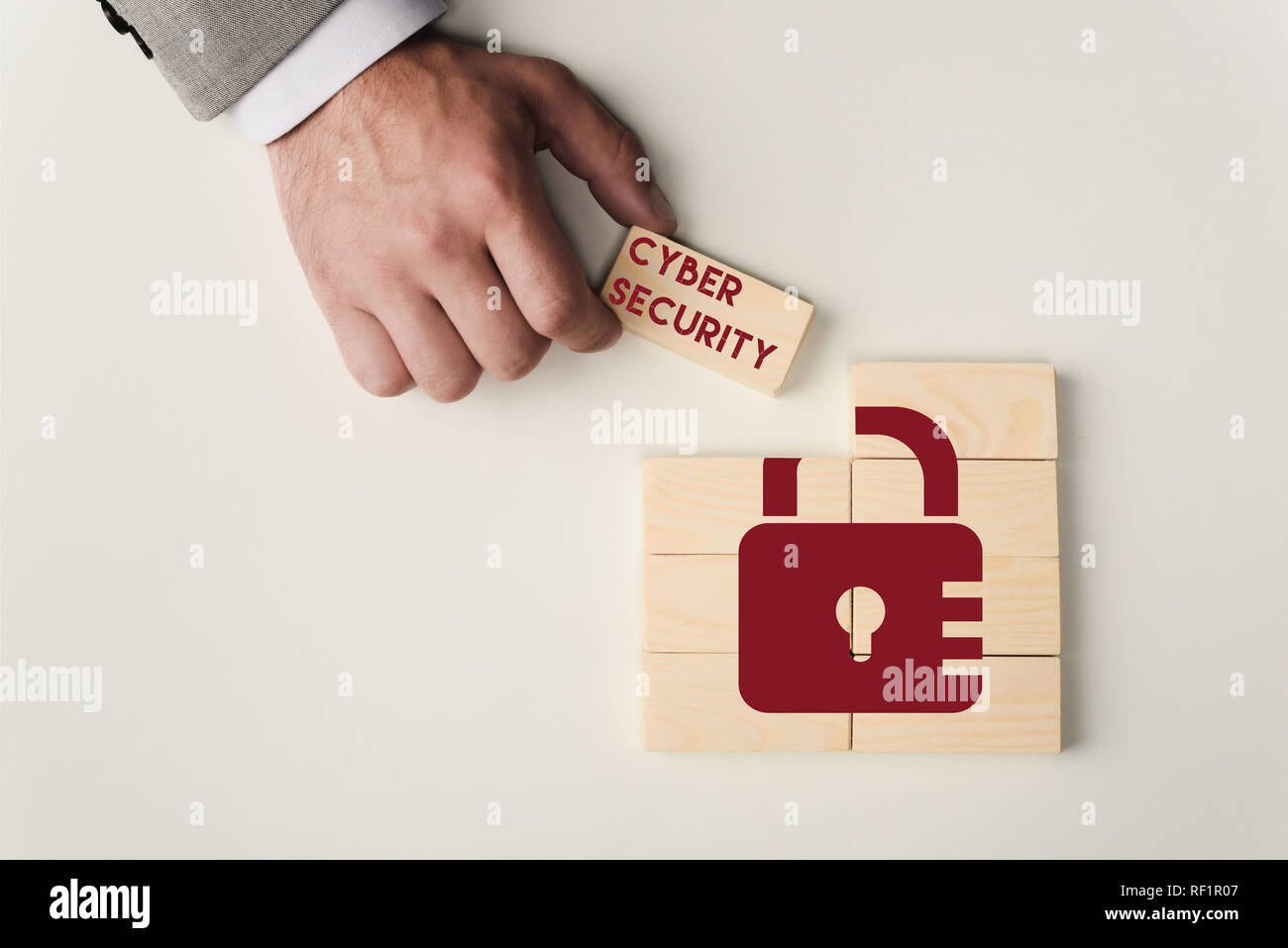 partial view of man holding brick with 'cyber security' lettering over ...