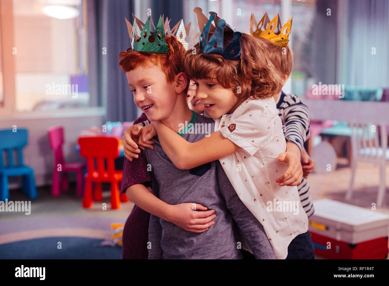 Positive delighted classmates celebrating their best friend Stock Photo ...