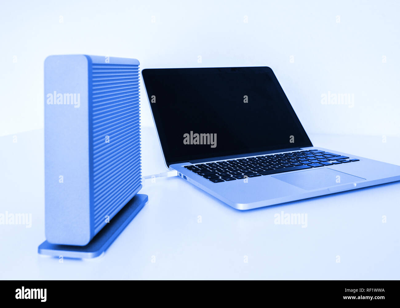 Blue tone image of external HDD hard disk drive next to modern powerful ...