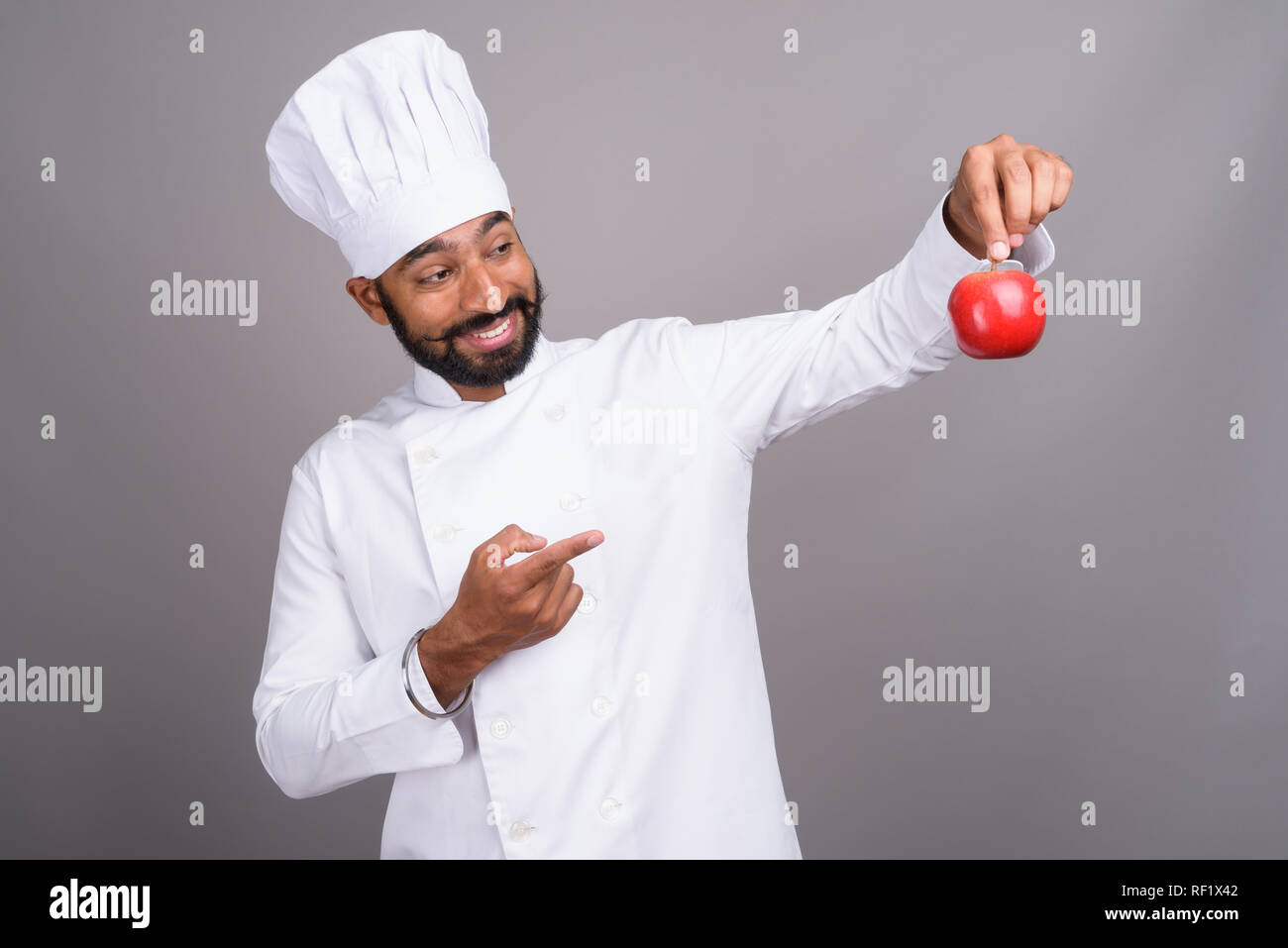 Young handsome Indian man chef holding apple Stock Photo - Alamy