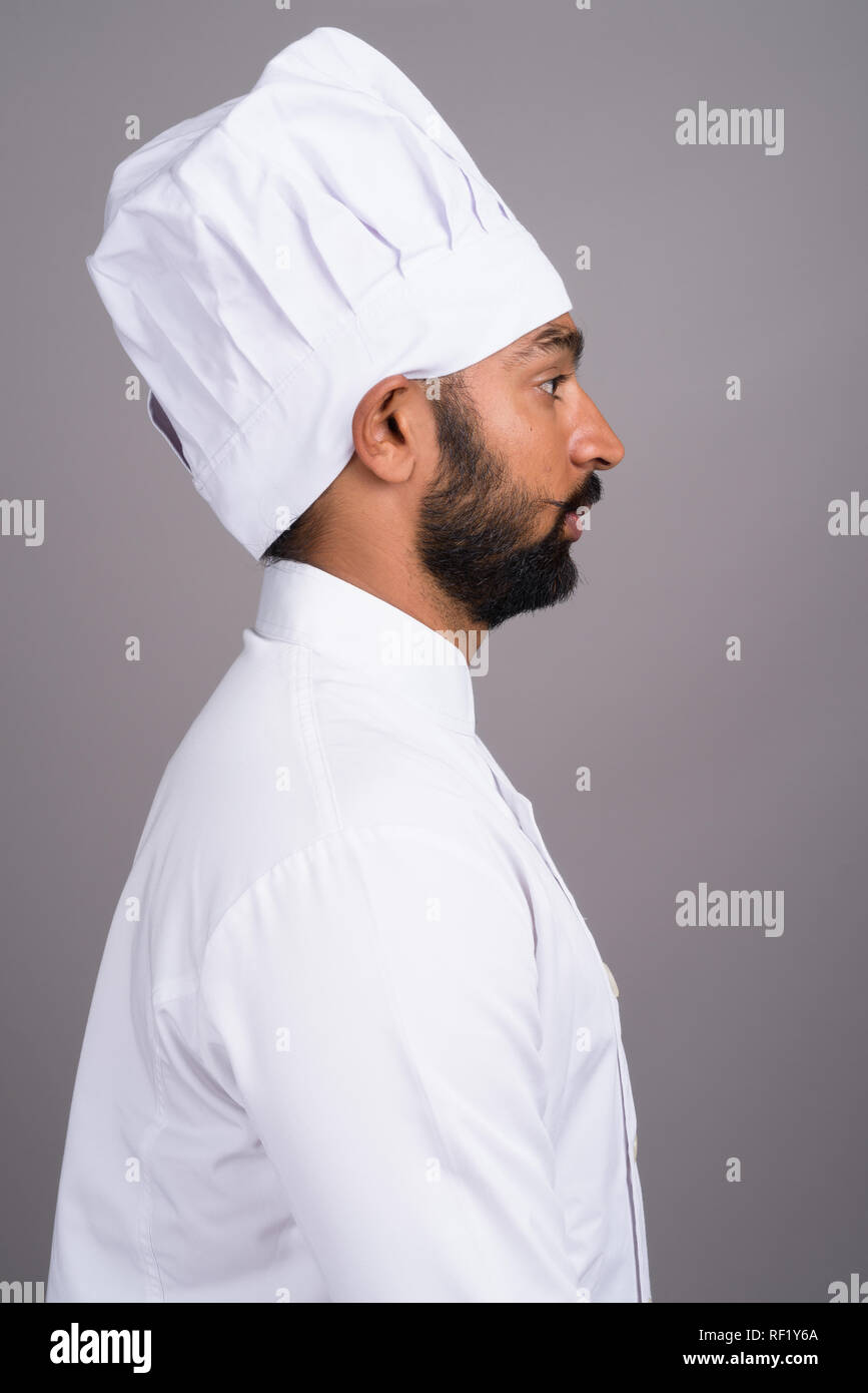 Profile view of young Indian man chef against gray background Stock ...