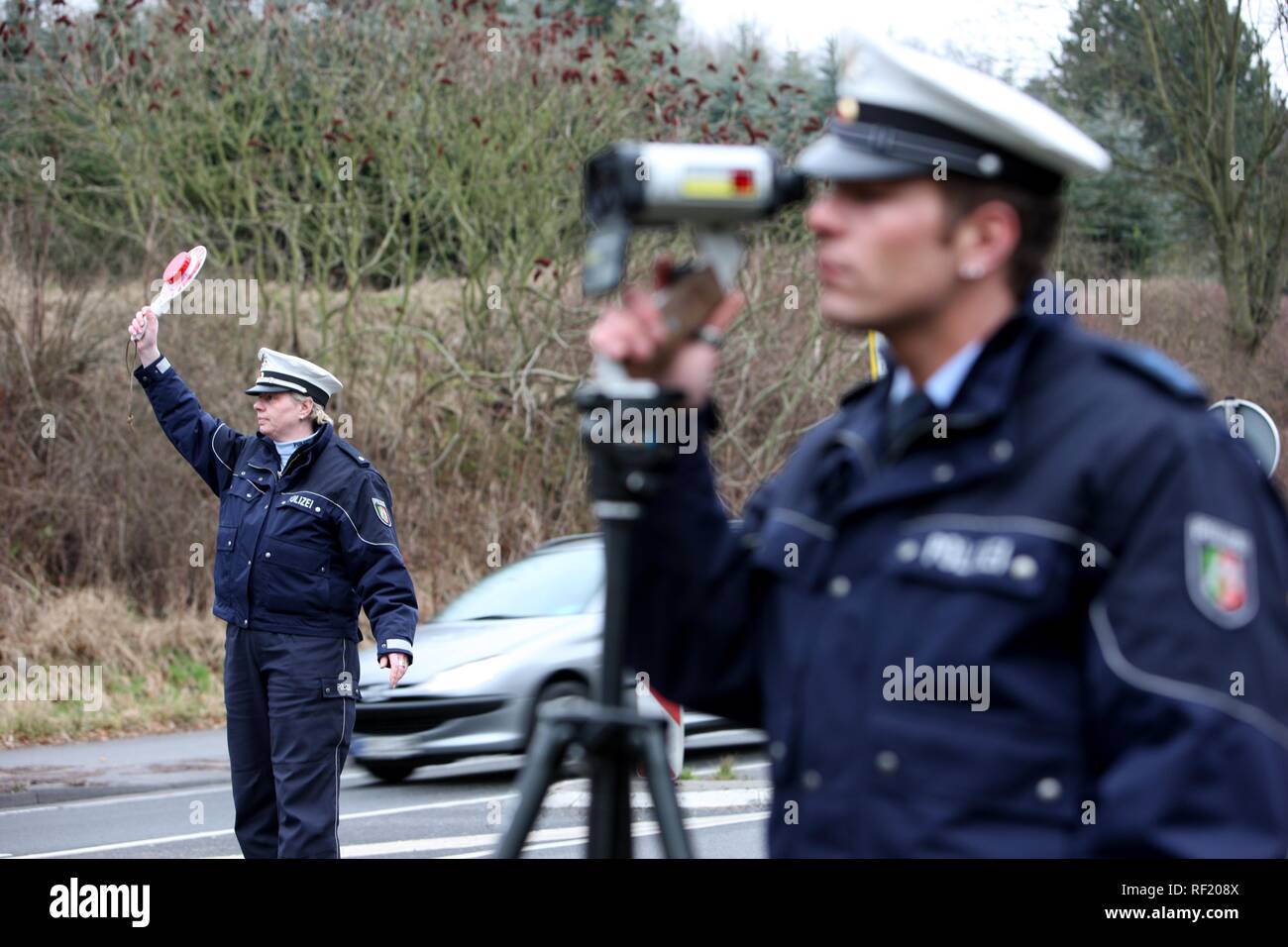 Speed limit enforcement, police measuring speed with a laser measuring ...