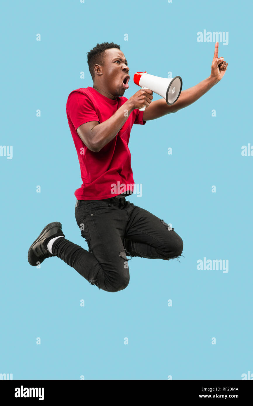 Soccer fan jumping on orange background. The young african man as ...