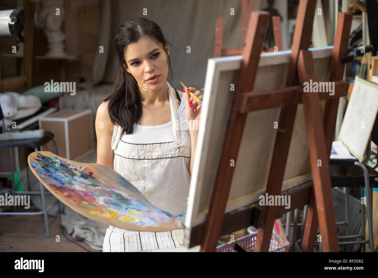 Professional Woman artist painting picture in art studio Stock Photo ...